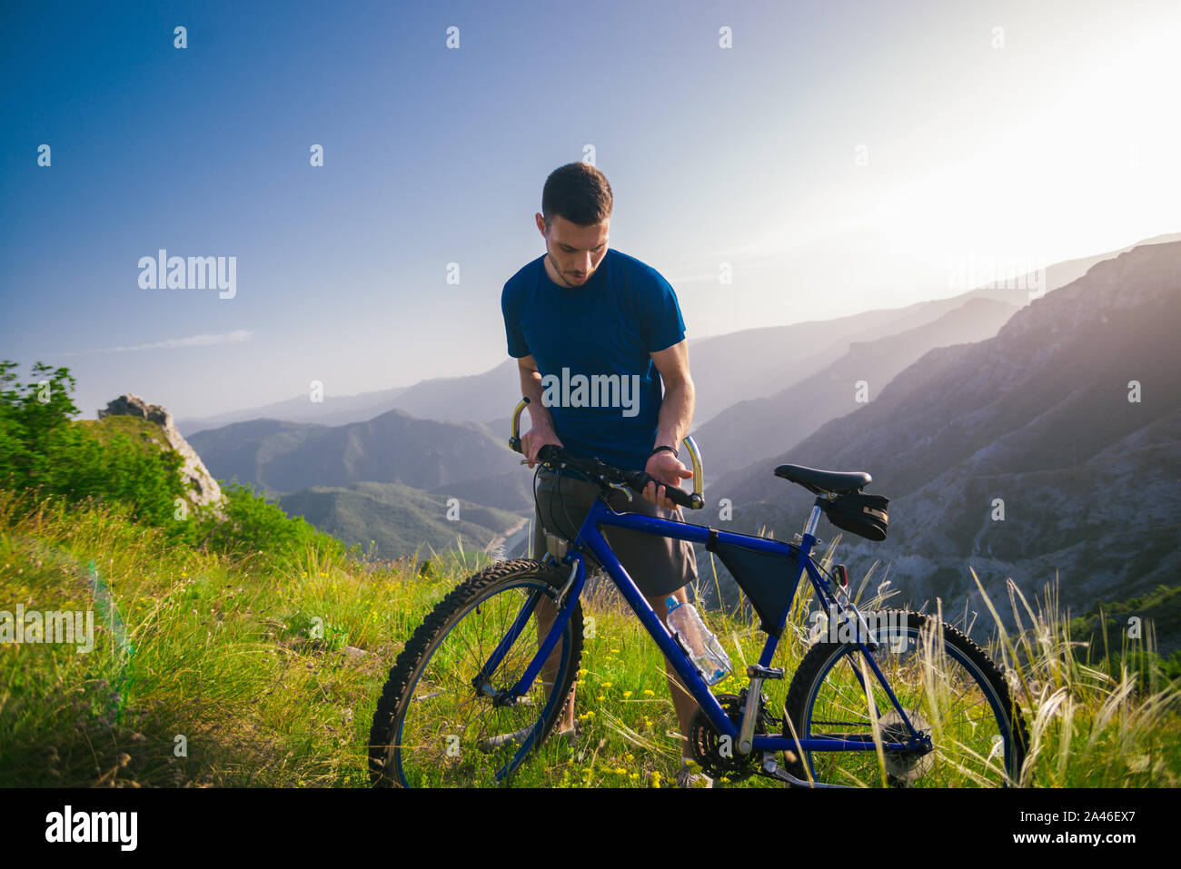 Perspective of a fit mountain biker pushing his bike uphill with ...