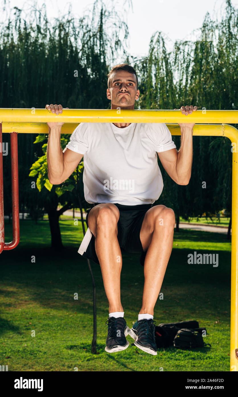 Fitness man exercising on chin-up bar. Guy doing chin-ups training ...