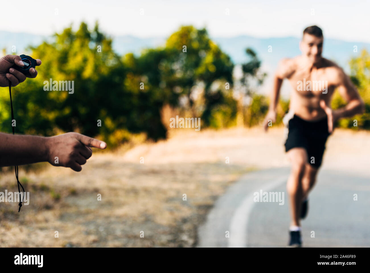 Running stopwatch in the hand against jogging man on mountain Stock ...