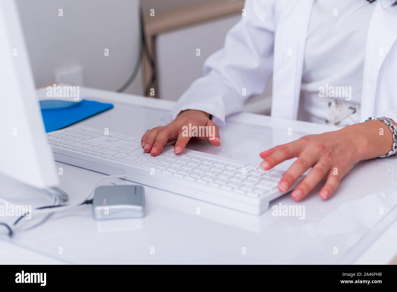 Close up hands of a female physician ( nurse ) typing on her white ...