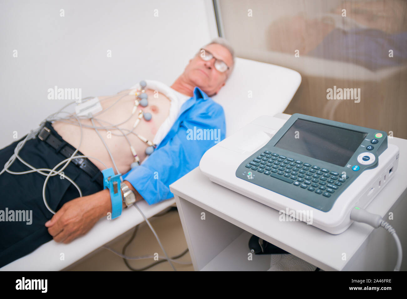 Doctor ( cardiologist ) is attaching vacuum sensors to an elder ...