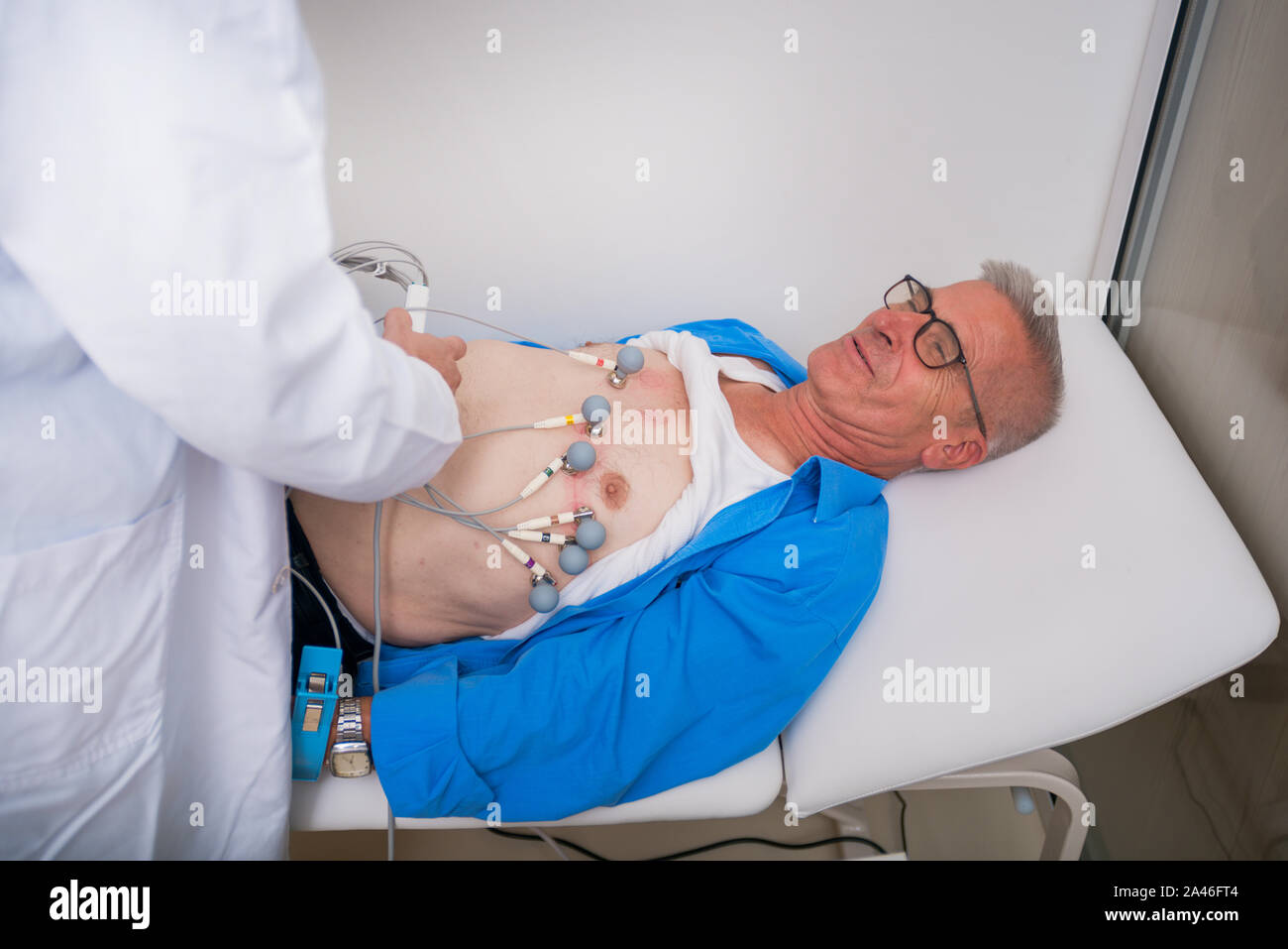 Doctor ( cardiologist ) is attaching vacuum sensors to an elder ...