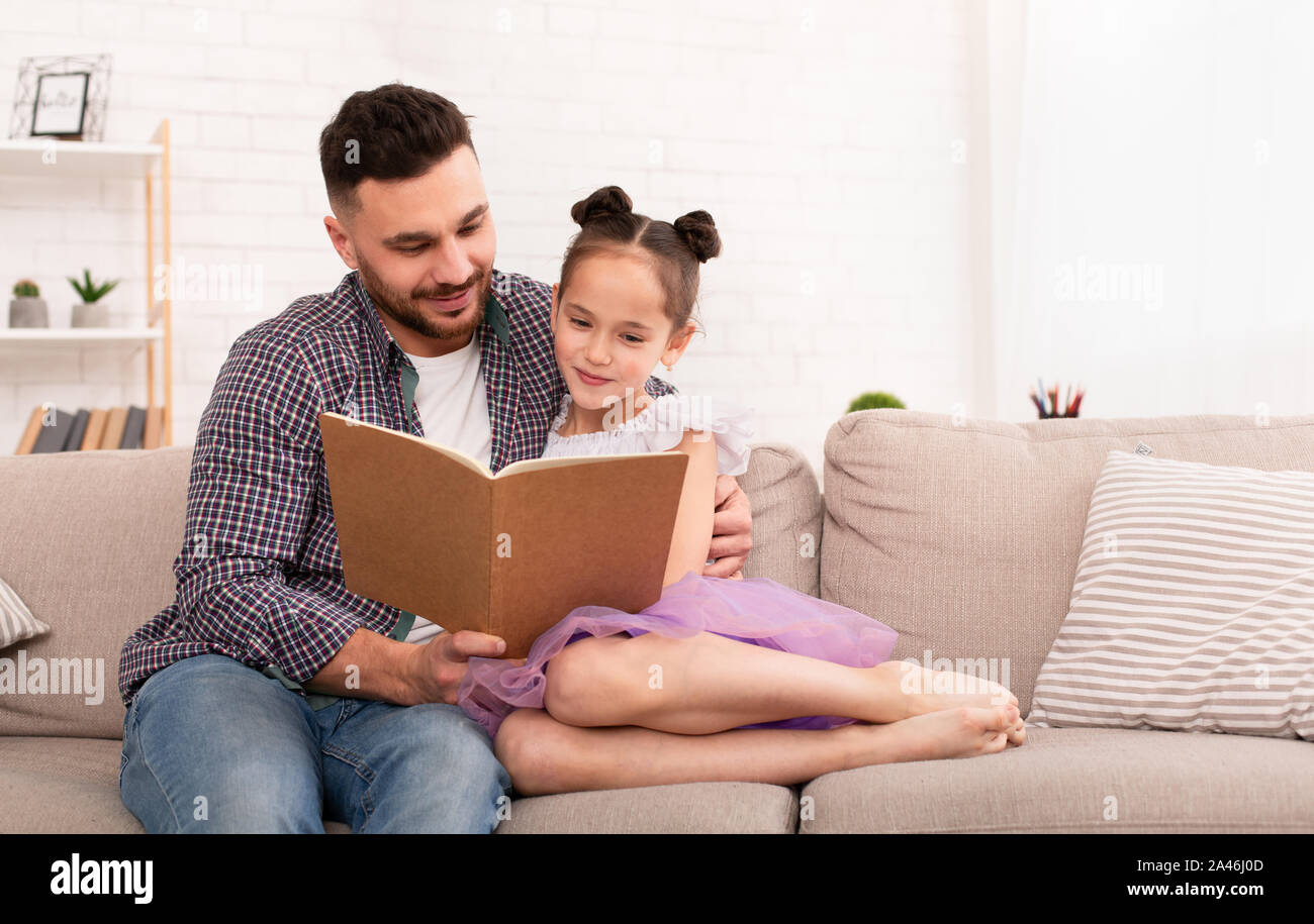 Caring daddy reading book to his cute daughter Stock Photo - Alamy