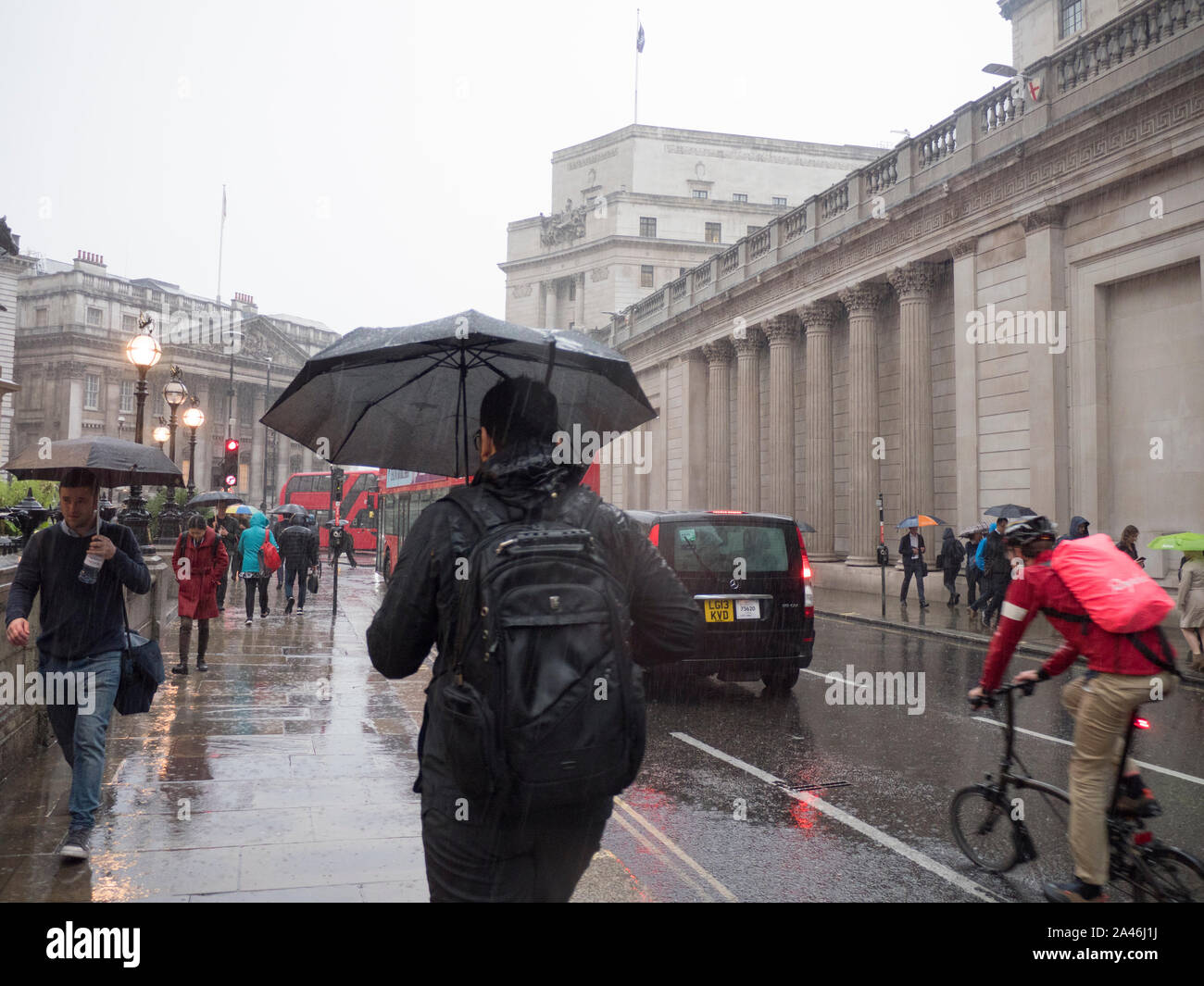 Pouring rain outside the bank of england with commuters and city ...
