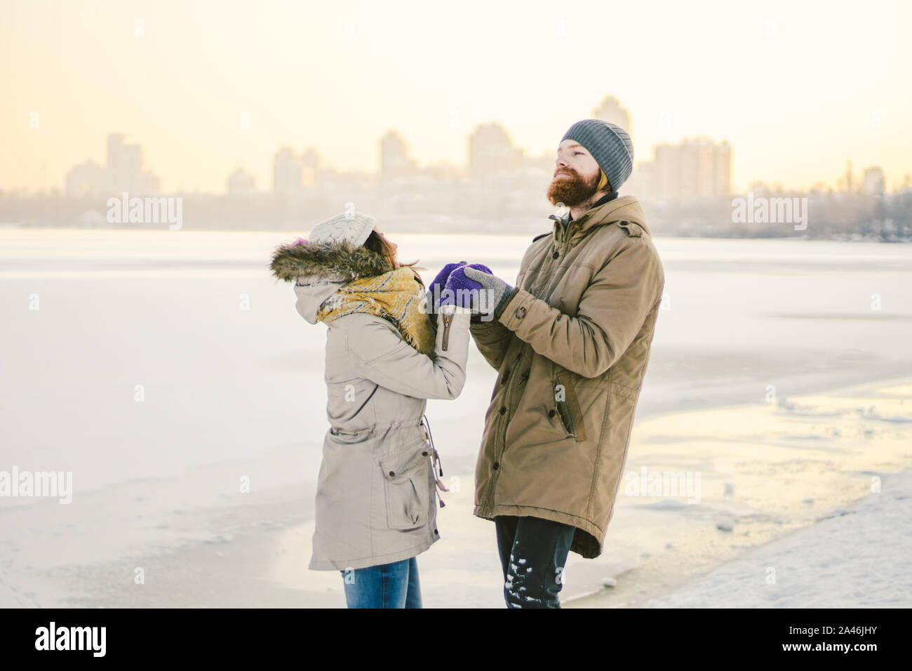 Young couple cheerfully flounders in snow. Between comic fight. Happy ...