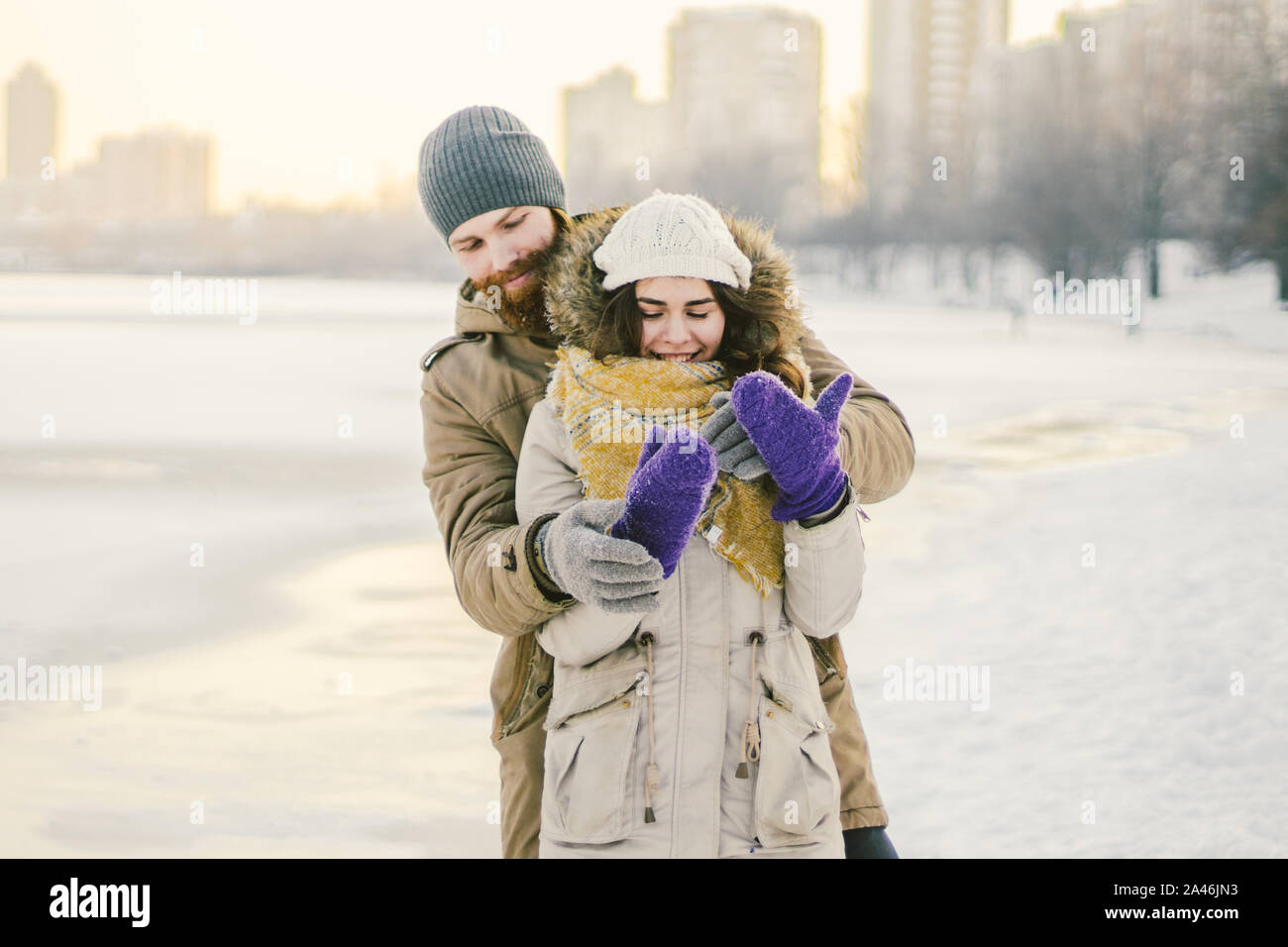 Young couple cheerfully flounders in snow. Between comic fight. Happy ...