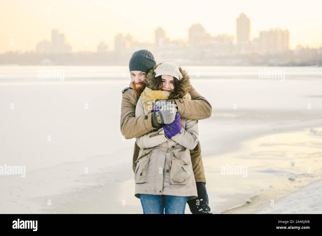 Young couple cheerfully flounders in snow. Between comic fight. Happy ...