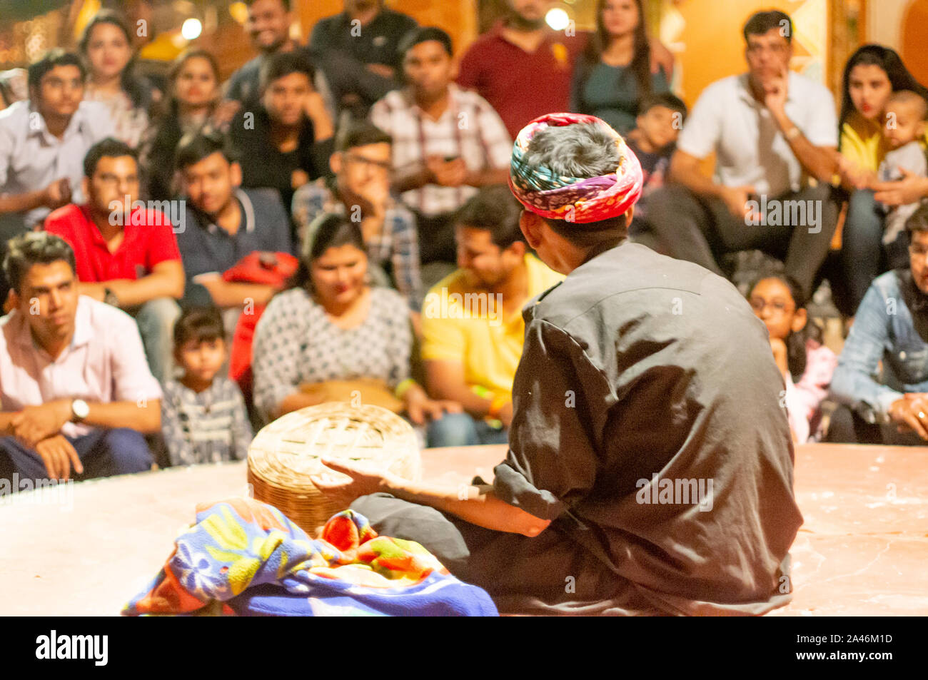 Traditional rajasthani man magician entertaining an out of focus crowd ...