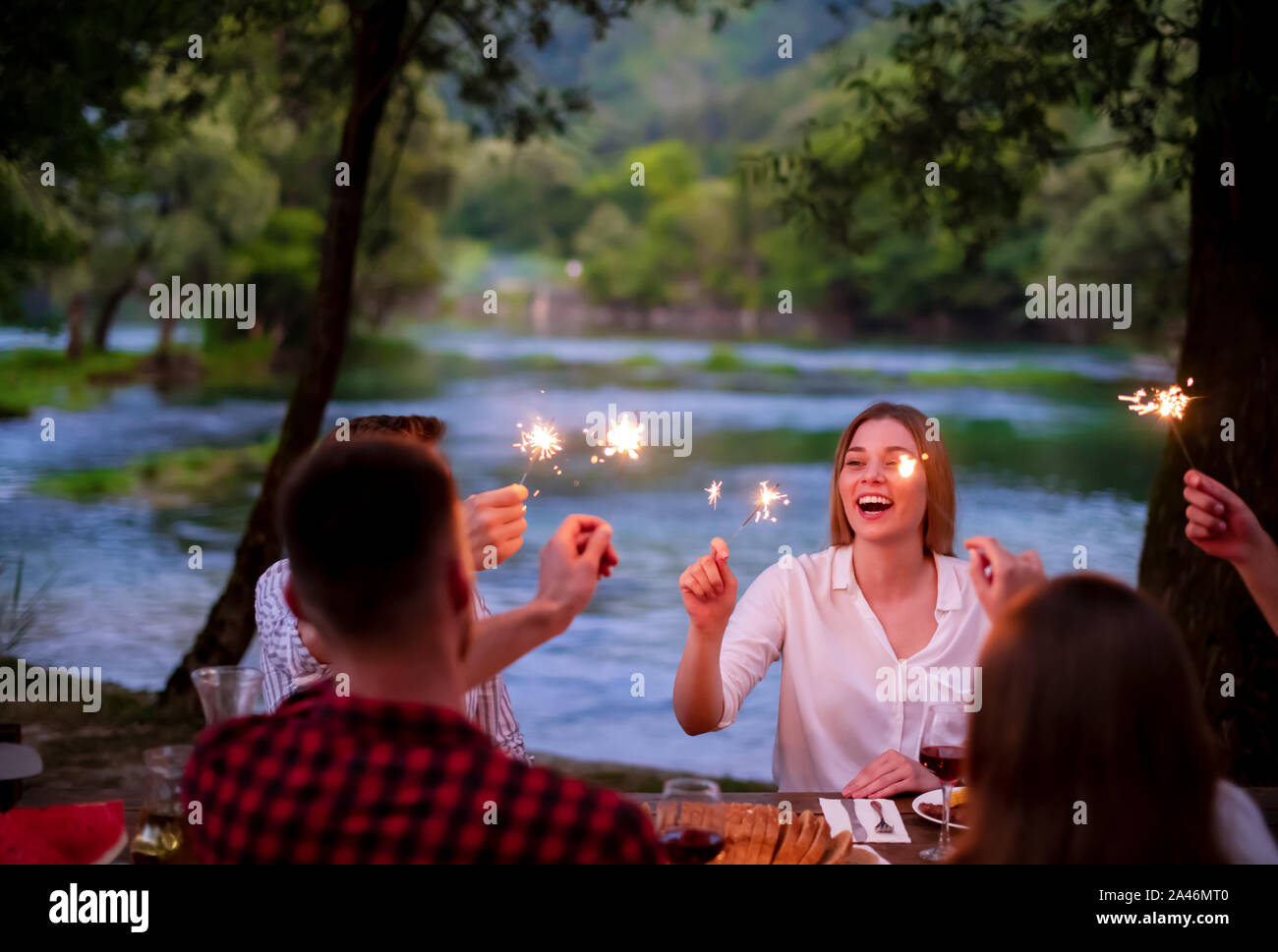group of happy friends celebrating holiday vacation using sprinklers ...