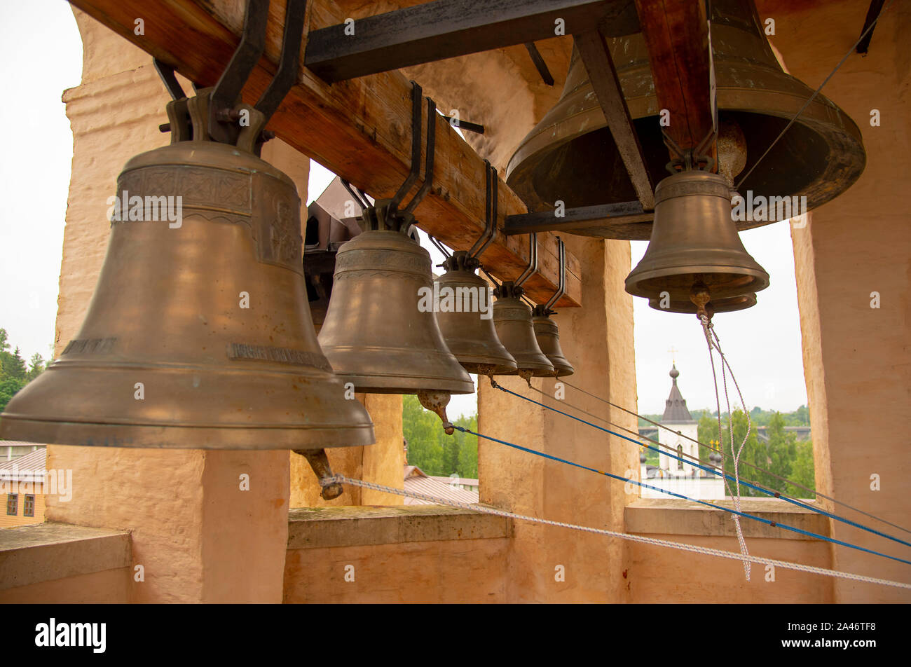 Bells of various sizes hang from a thick wooden beam Stock Photo - Alamy