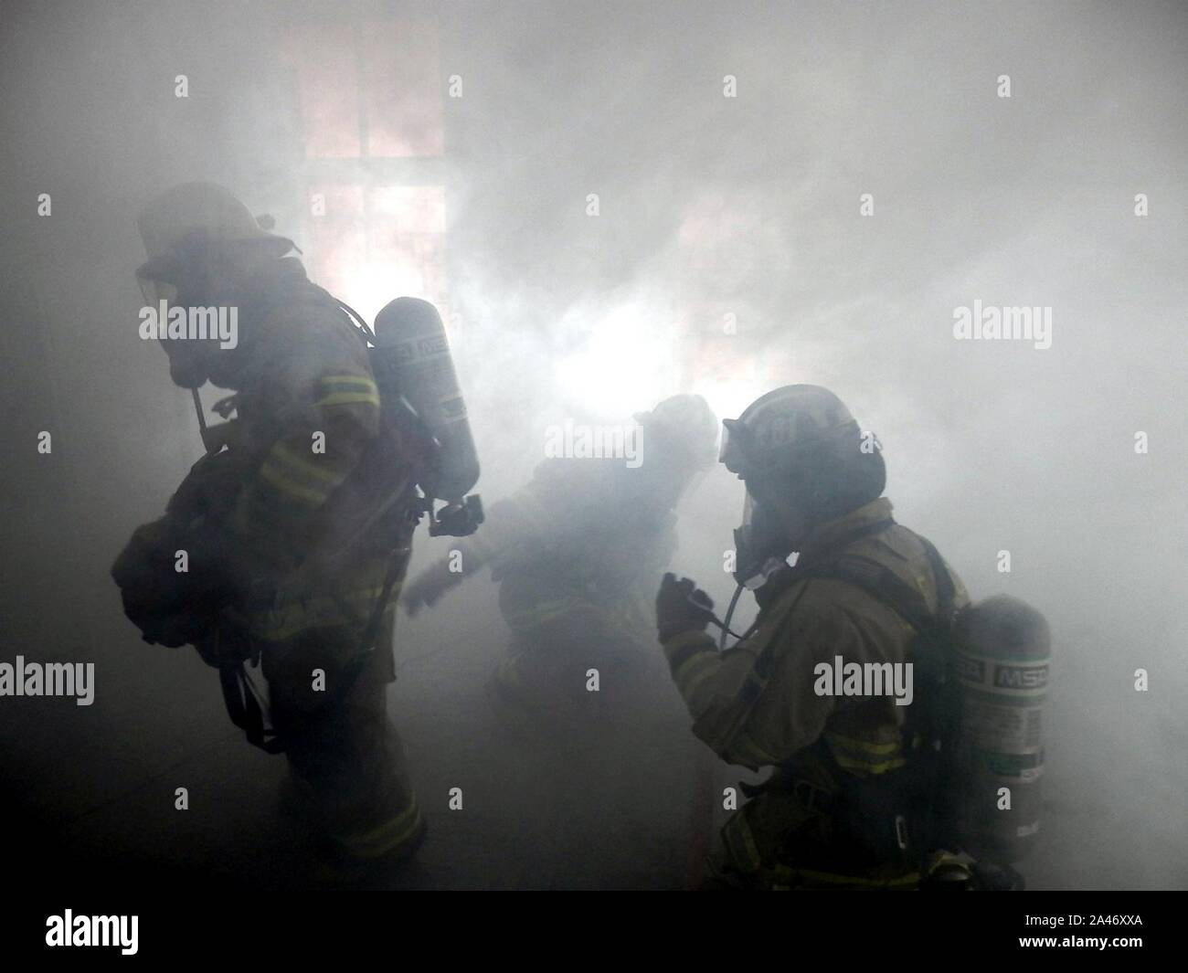 Firefighters navigate a smoke-filled room Stock Photo - Alamy
