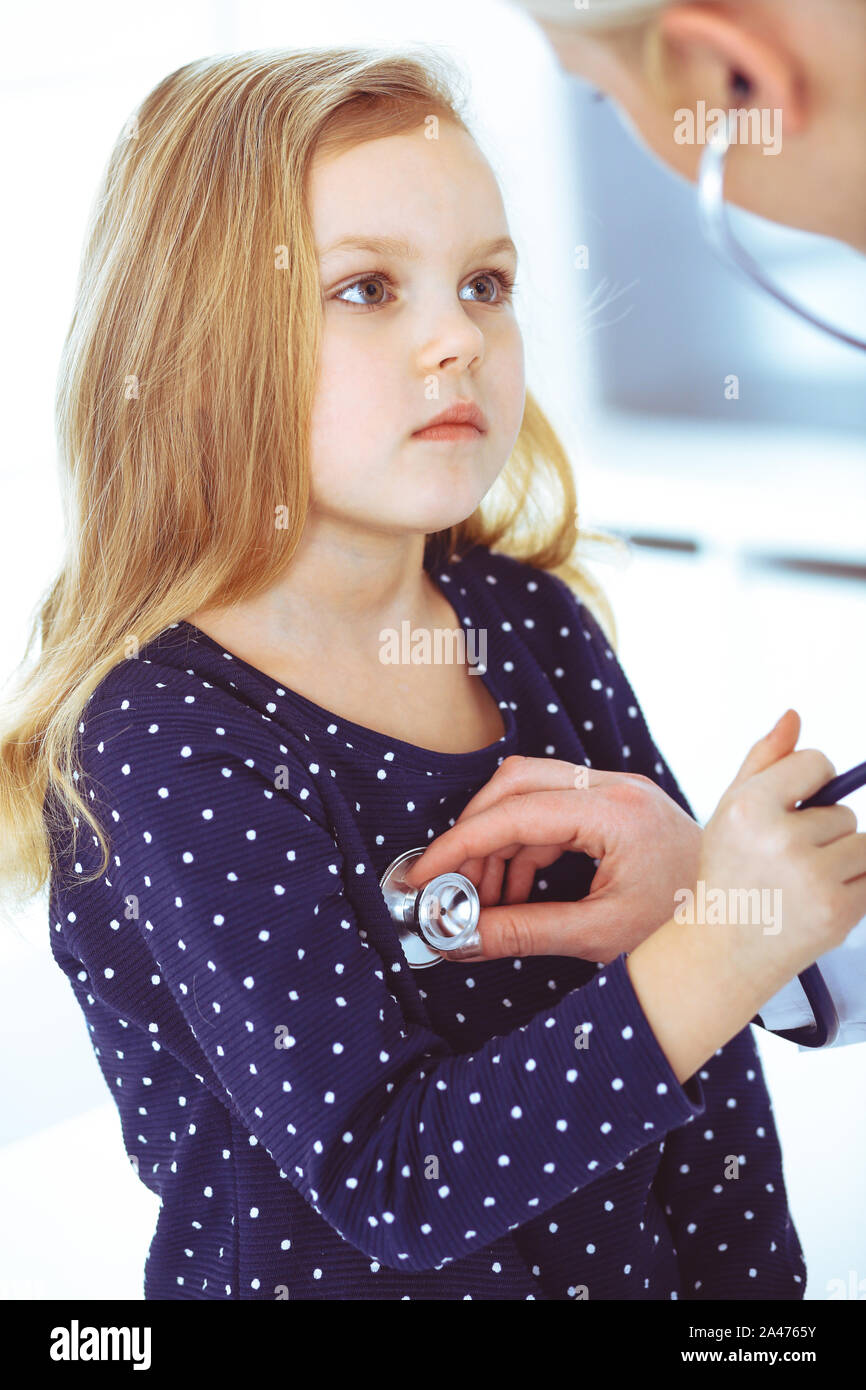 Doctor examining a child patient by stethoscope. Cute baby girl at ...