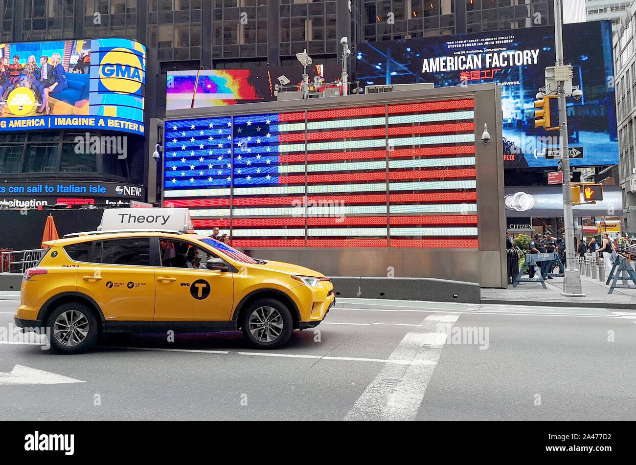 New York, USA. 14th Sep, 2019. A yellow taxi passes a neon-lit US flag ...