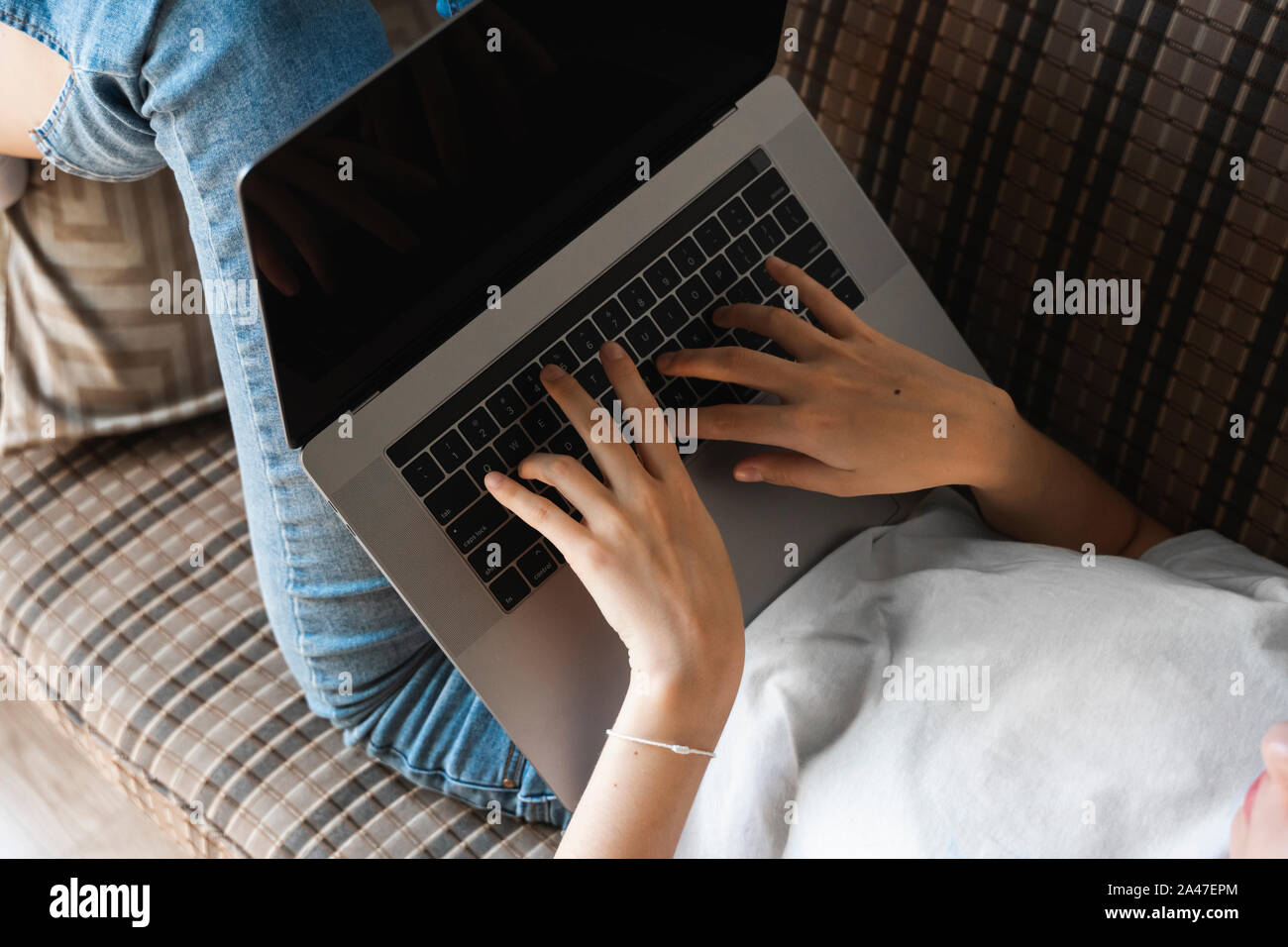 Woman with a laptop laying on a sofa. Study and work online, freelance ...