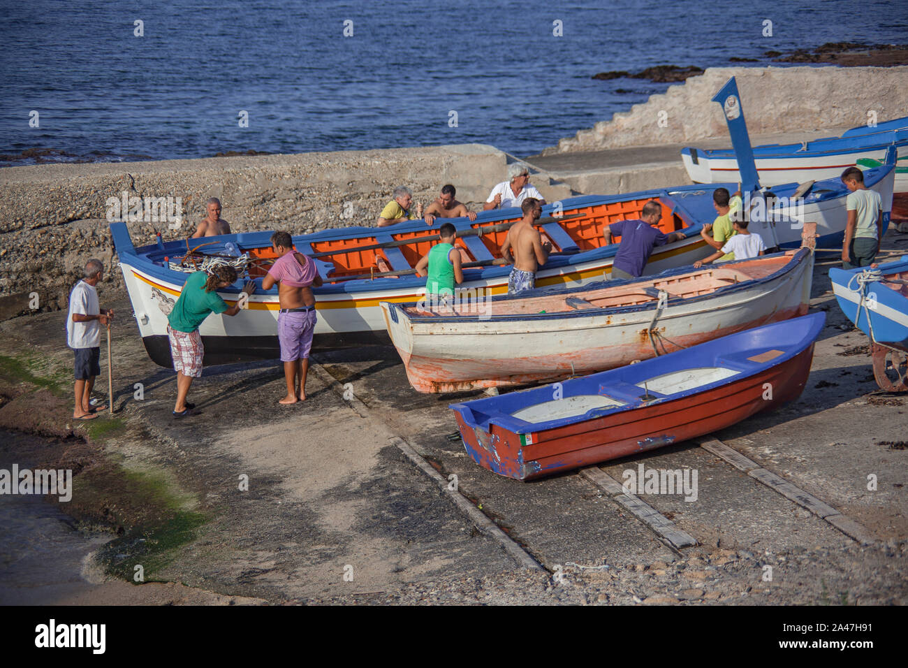 Men bring boat out of the water Stock Photo - Alamy