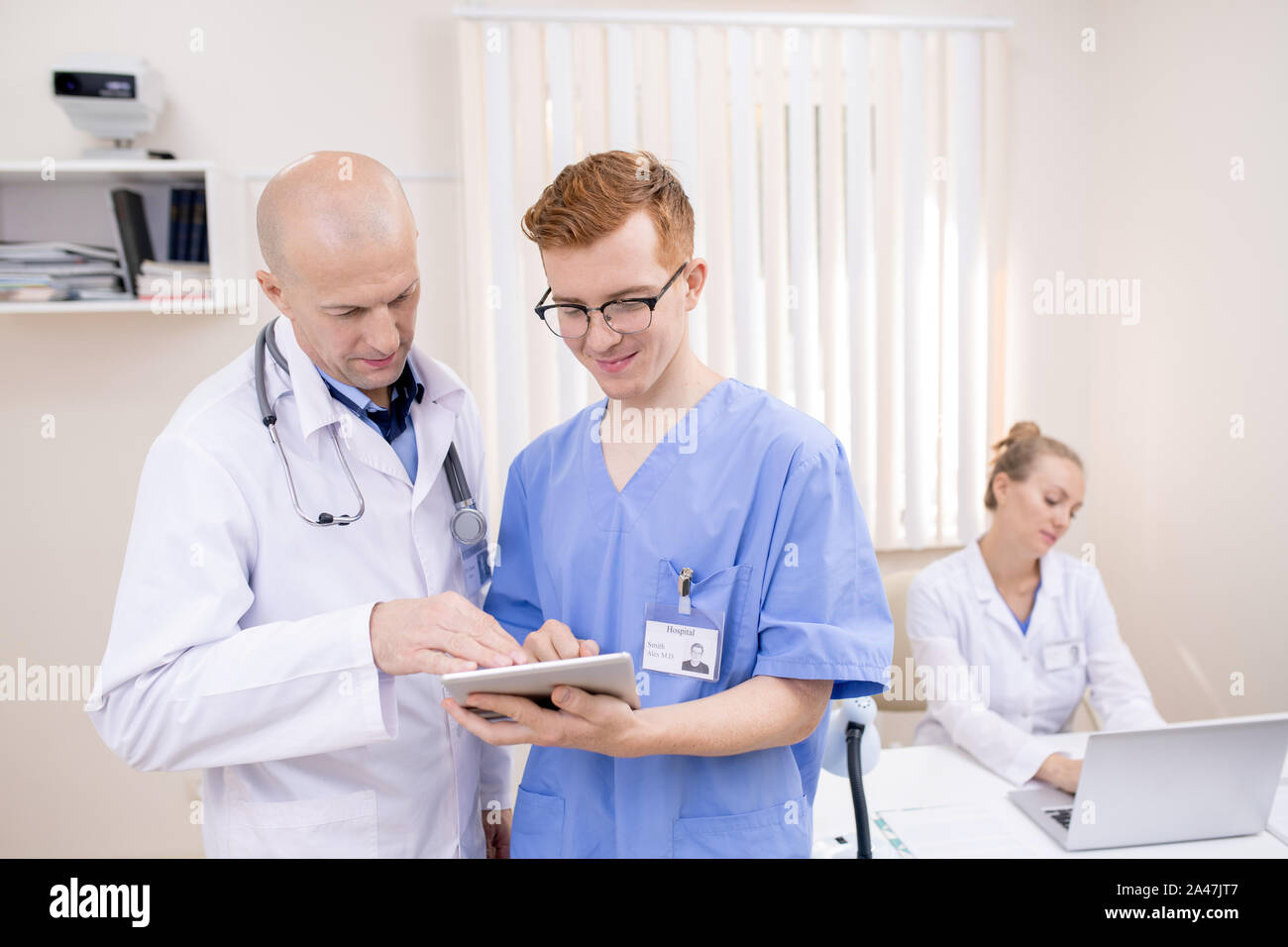 Two clinicians in uniform looking through electronic document on ...