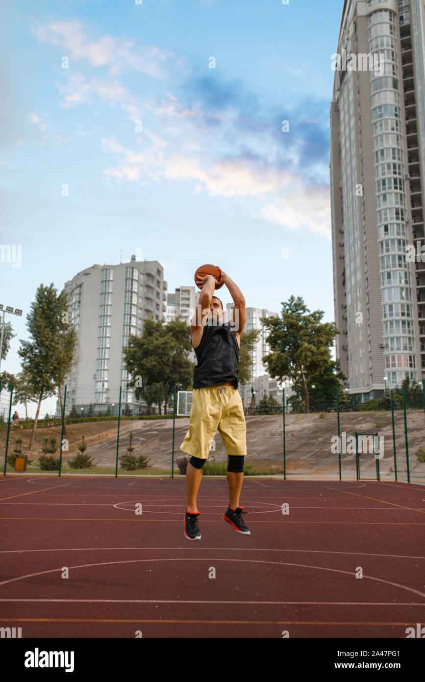 Basketball player makes a throw on outdoor court Stock Photo - Alamy