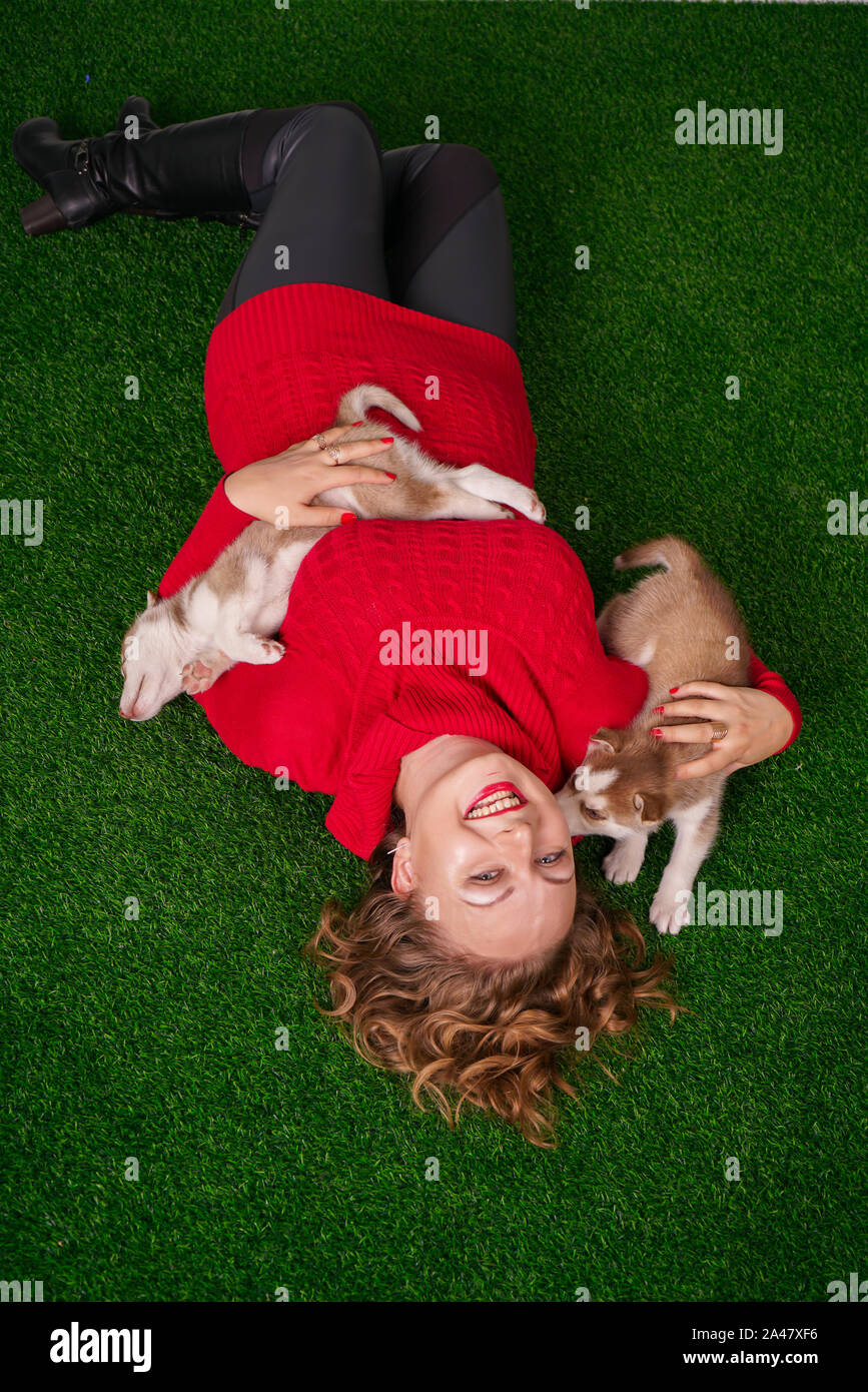 pretty caucasian plus size woman in red sweater with two cute husky ...