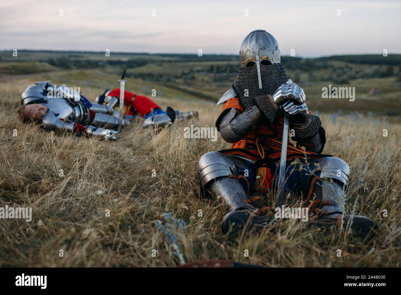 Medieval knight in armor sitting on the ground Stock Photo - Alamy
