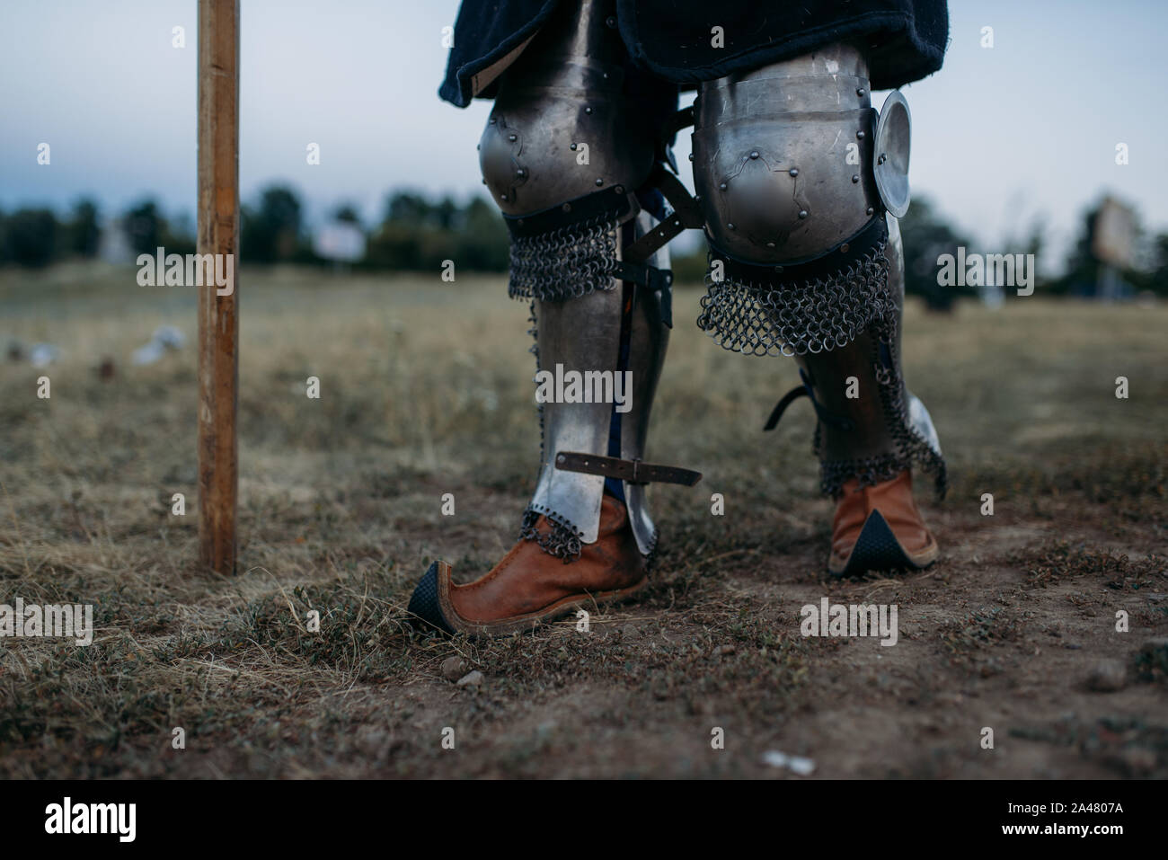 Medieval knight legs in metal armor, back view Stock Photo - Alamy