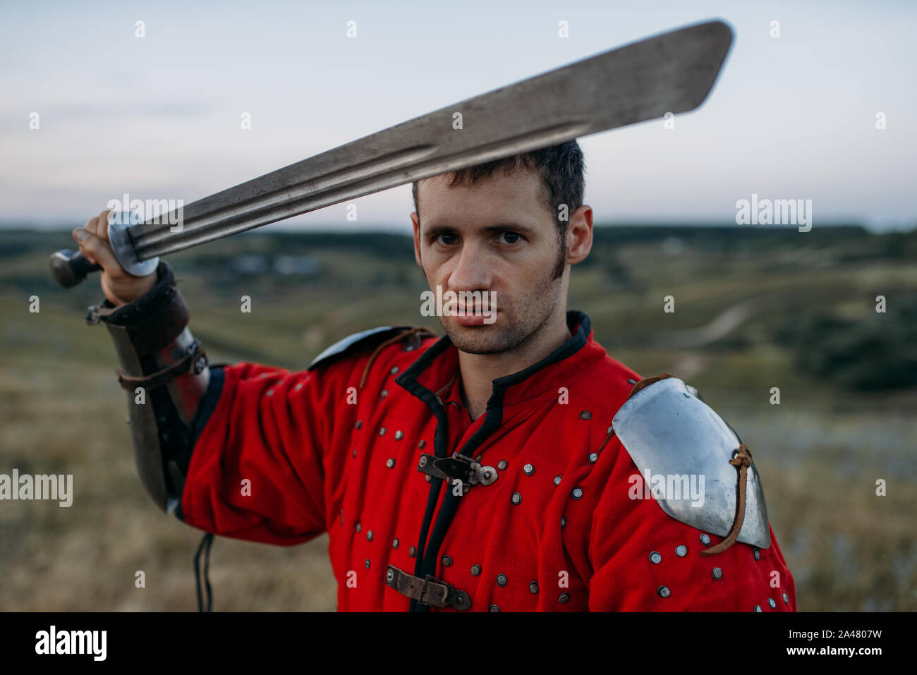 Medieval knight in metal helmet holds sword Stock Photo - Alamy