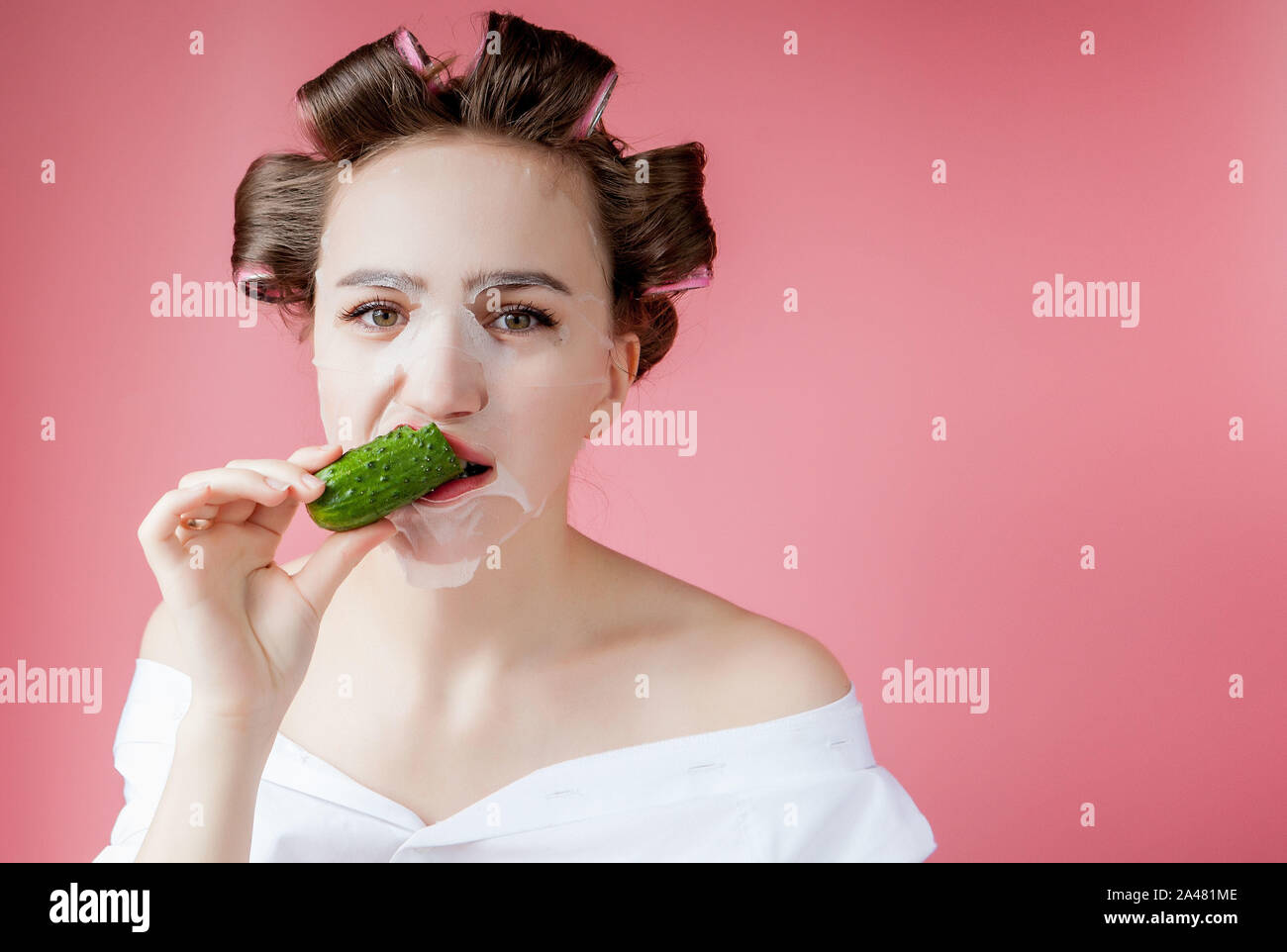 Beautiful young girl with a mask and curlers touching her face Stock ...