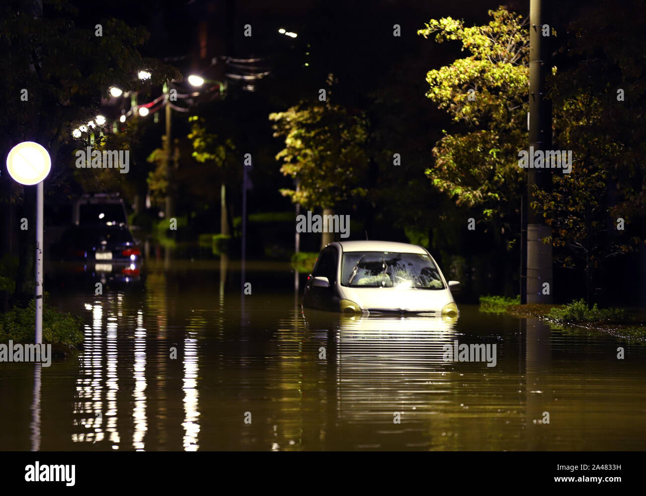 Tokyo, Japan. 12th Oct, 2019. A vehicle is merged under flooded water ...