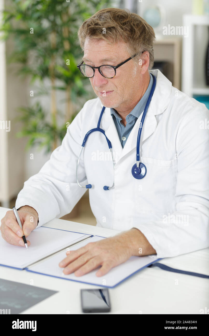 a senior doctor writing notes Stock Photo - Alamy