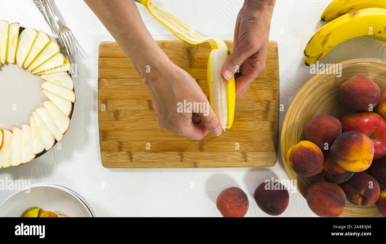 Banana Slices on a Wooden Chopping Board. Woman Peeling and Slicing ...