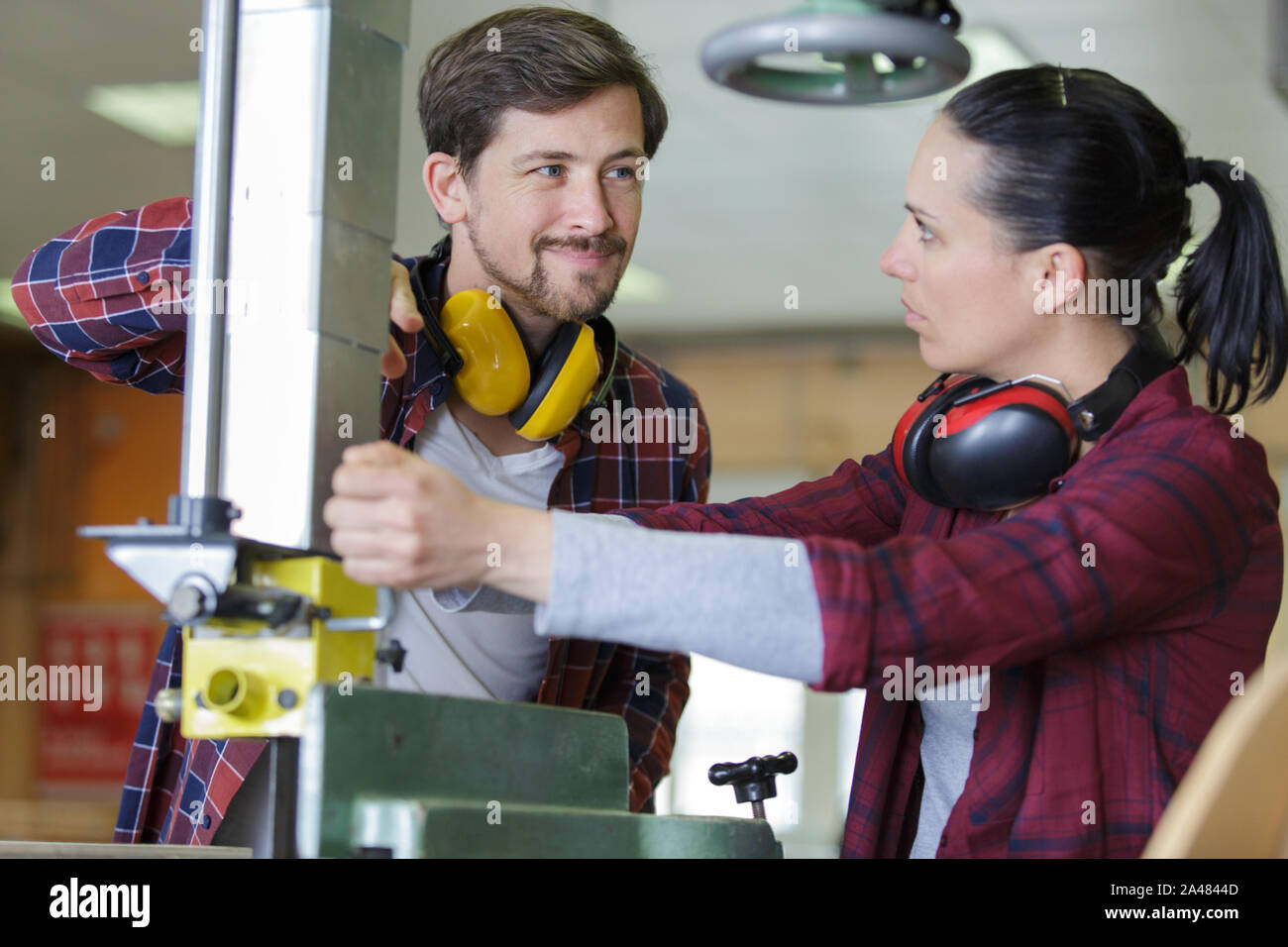 female worker using industrial machine under supervision Stock Photo ...