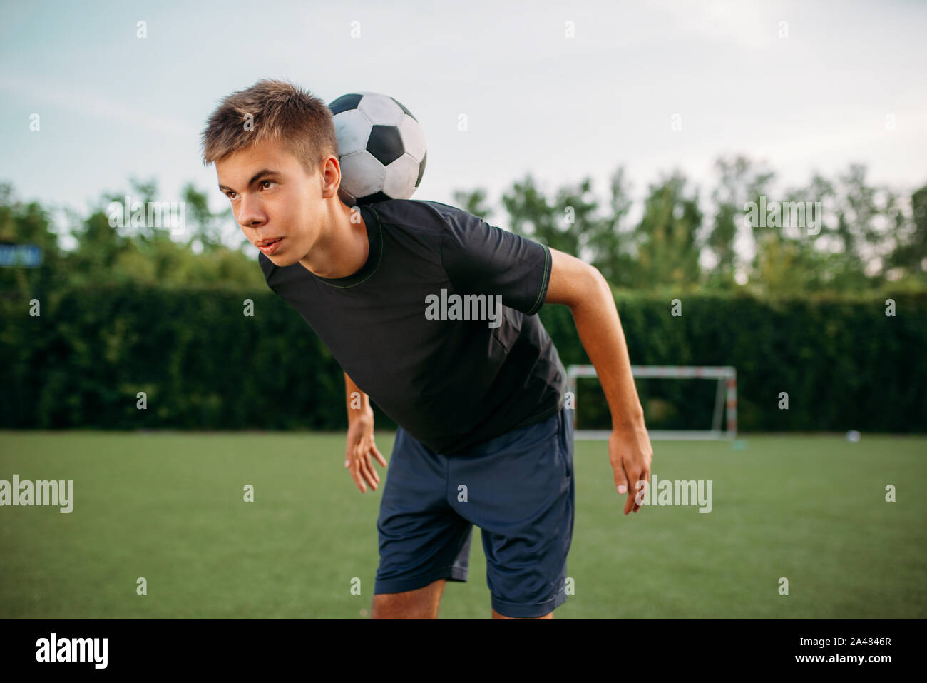 Soccer player keeps balance with ball on his neck Stock Photo - Alamy