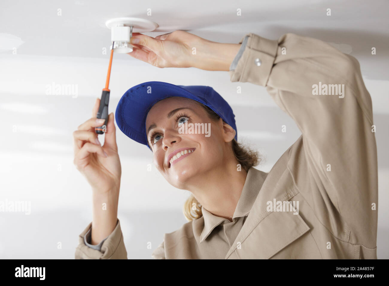 portrait of a woman installing a light bulb Stock Photo - Alamy