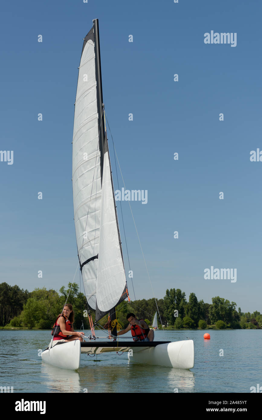 verical view of young couple in sailing vessel on lake Stock Photo - Alamy