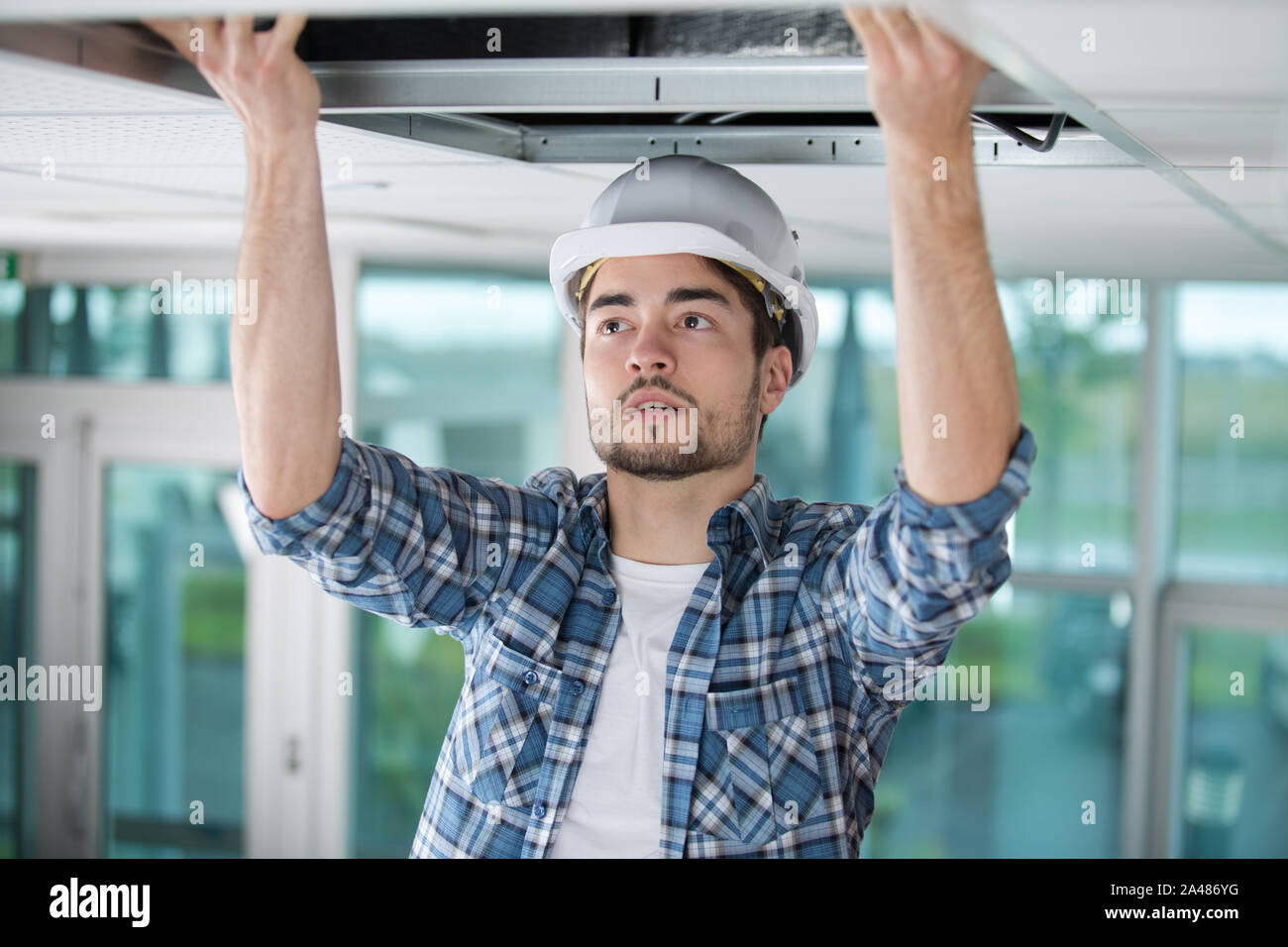 workman placing overhead ceiling panel Stock Photo - Alamy