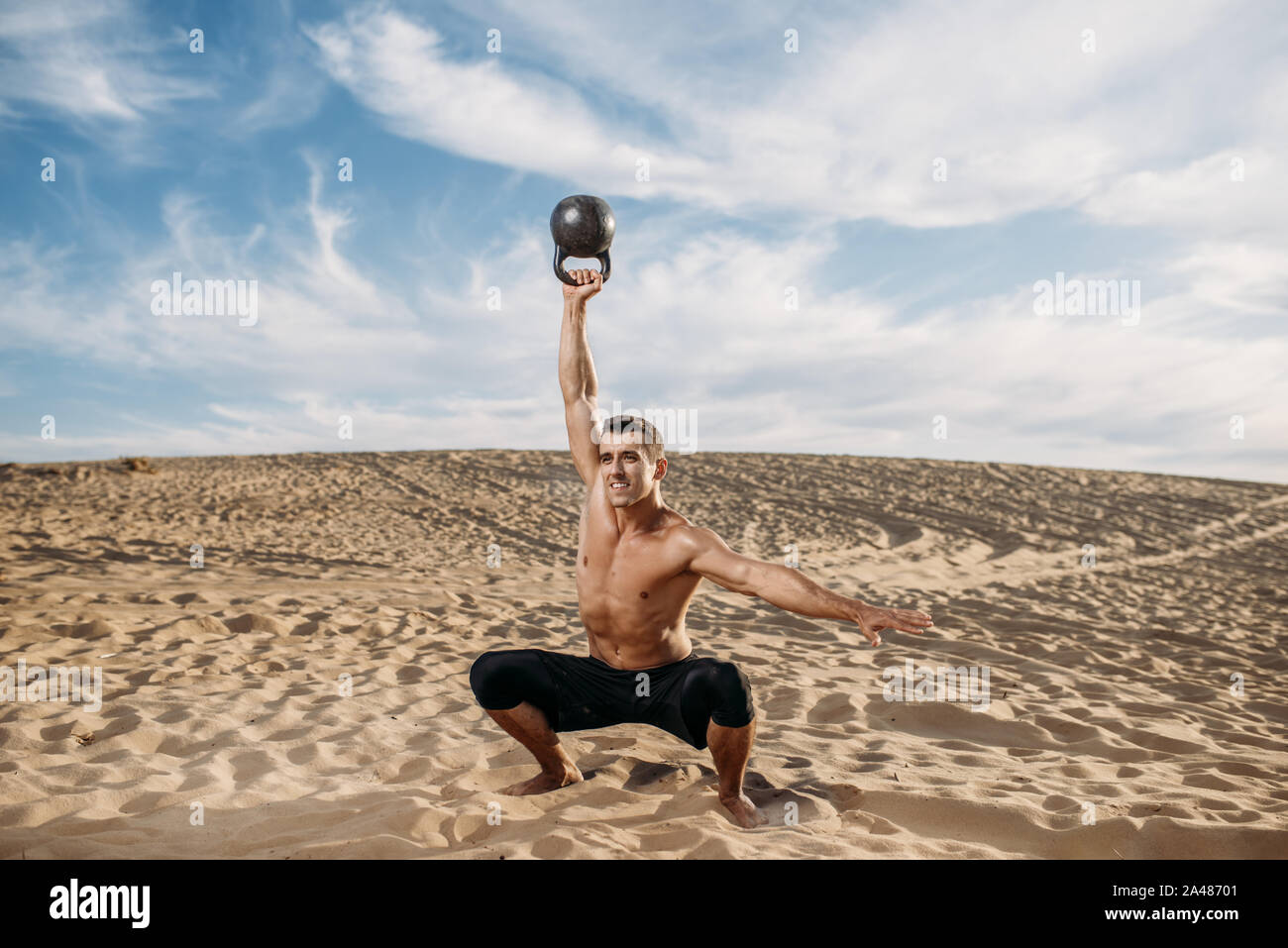 Male athlete doing exercise with weights in desert Stock Photo - Alamy