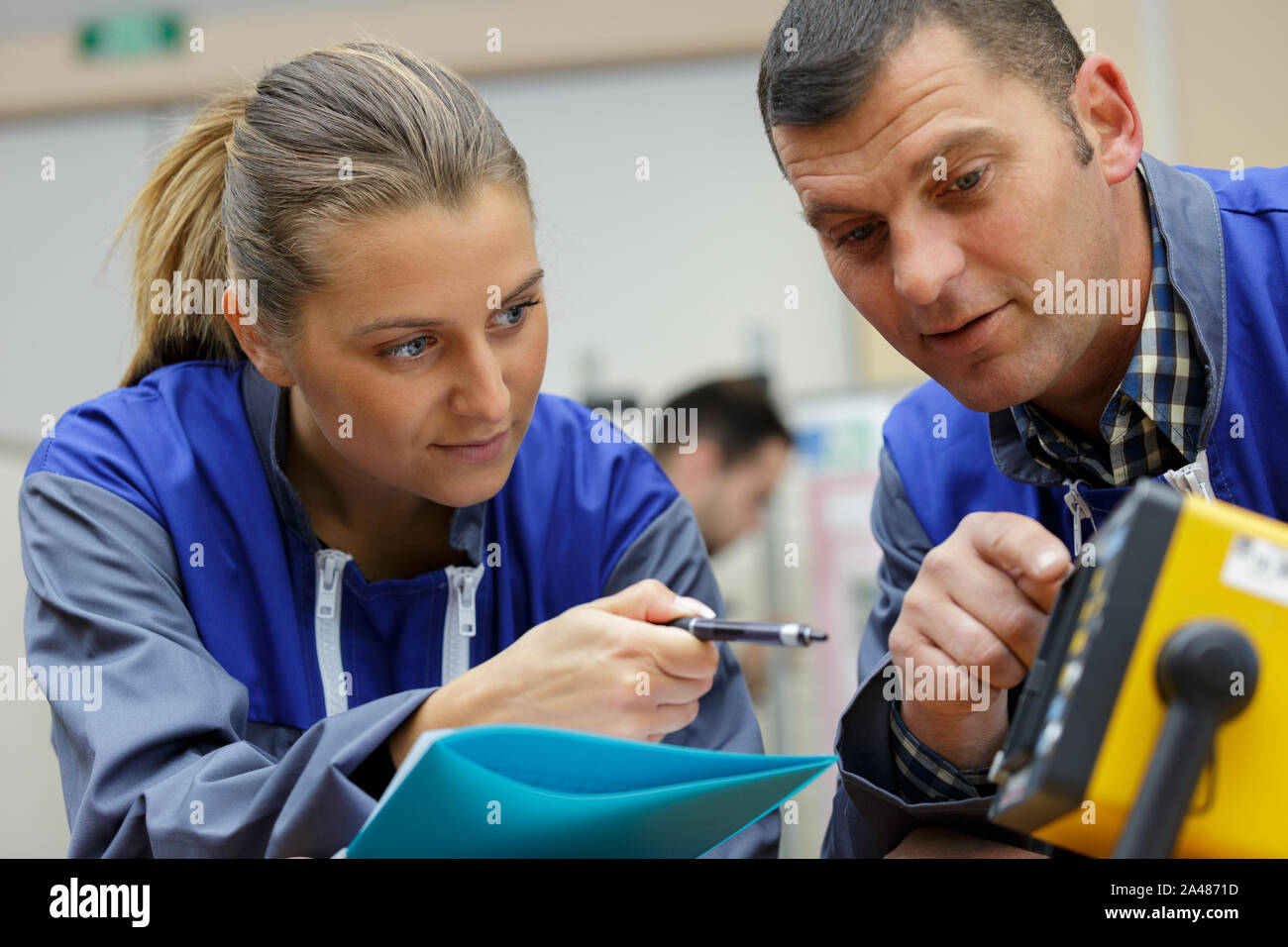 metal worker teaching trainee on machine use Stock Photo - Alamy