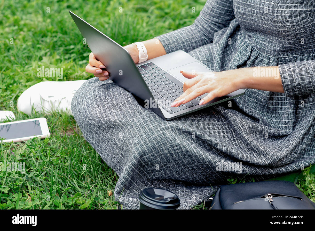 Cropped image of female is working on laptop computer while sitting on ...