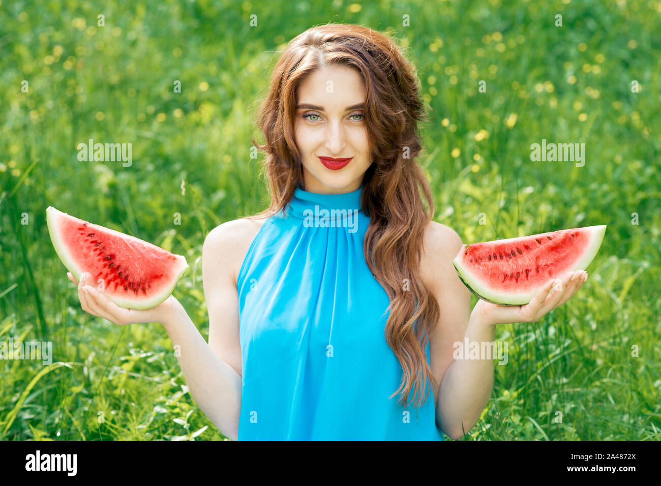 Portrait of attractive young girl holds two slices of juicy watermelon ...