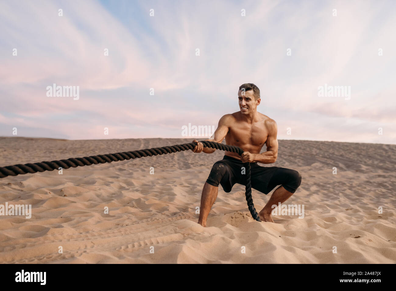 Athlete doing exercise with battle ropes in desert Stock Photo - Alamy