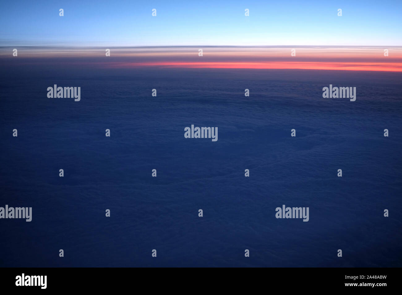 Aerial view through airplane porthole of purple sunset in sky. Sunset ...