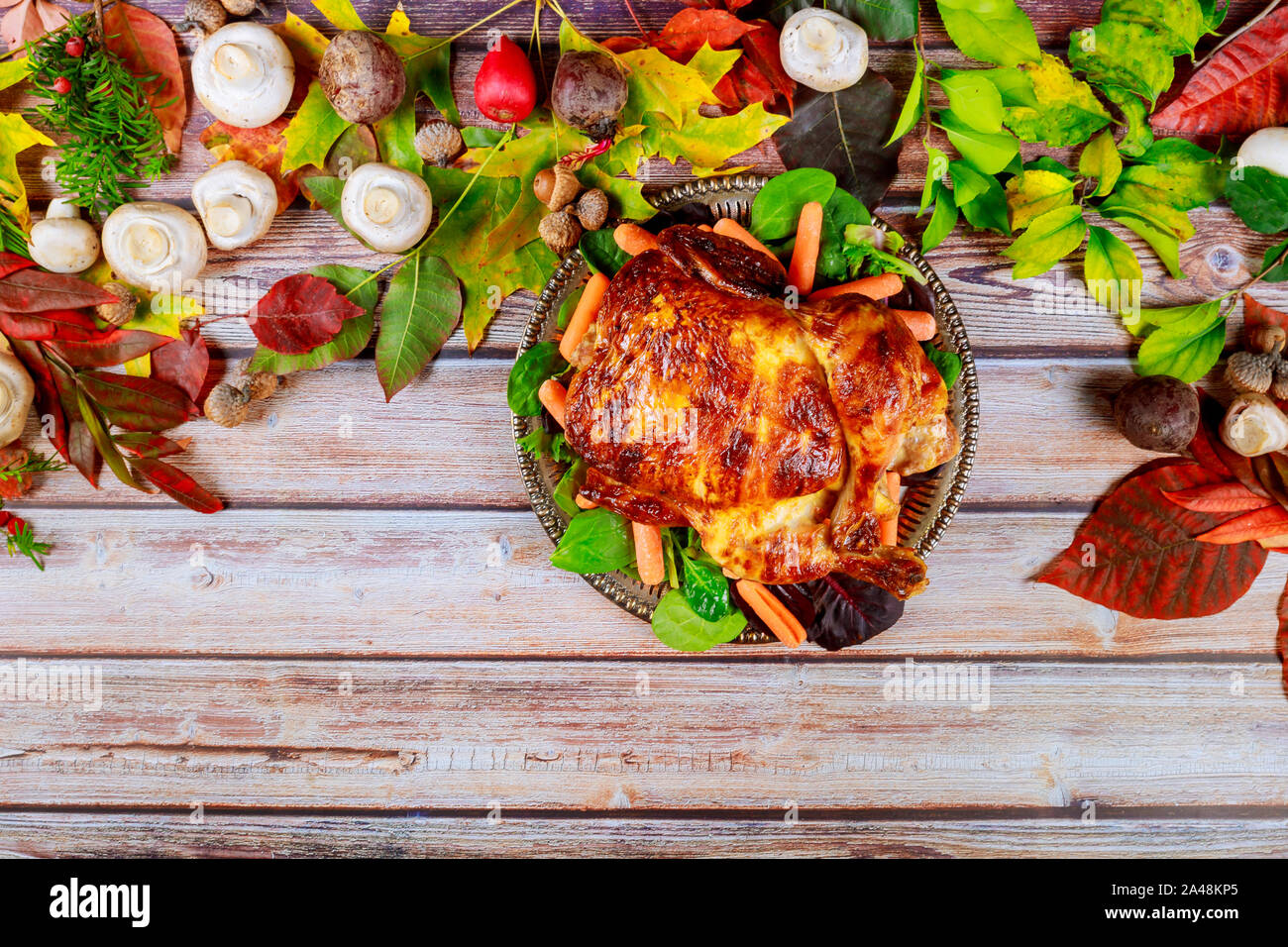 Baked whole fried chicken with mushrooms close-up on a table. vertical ...