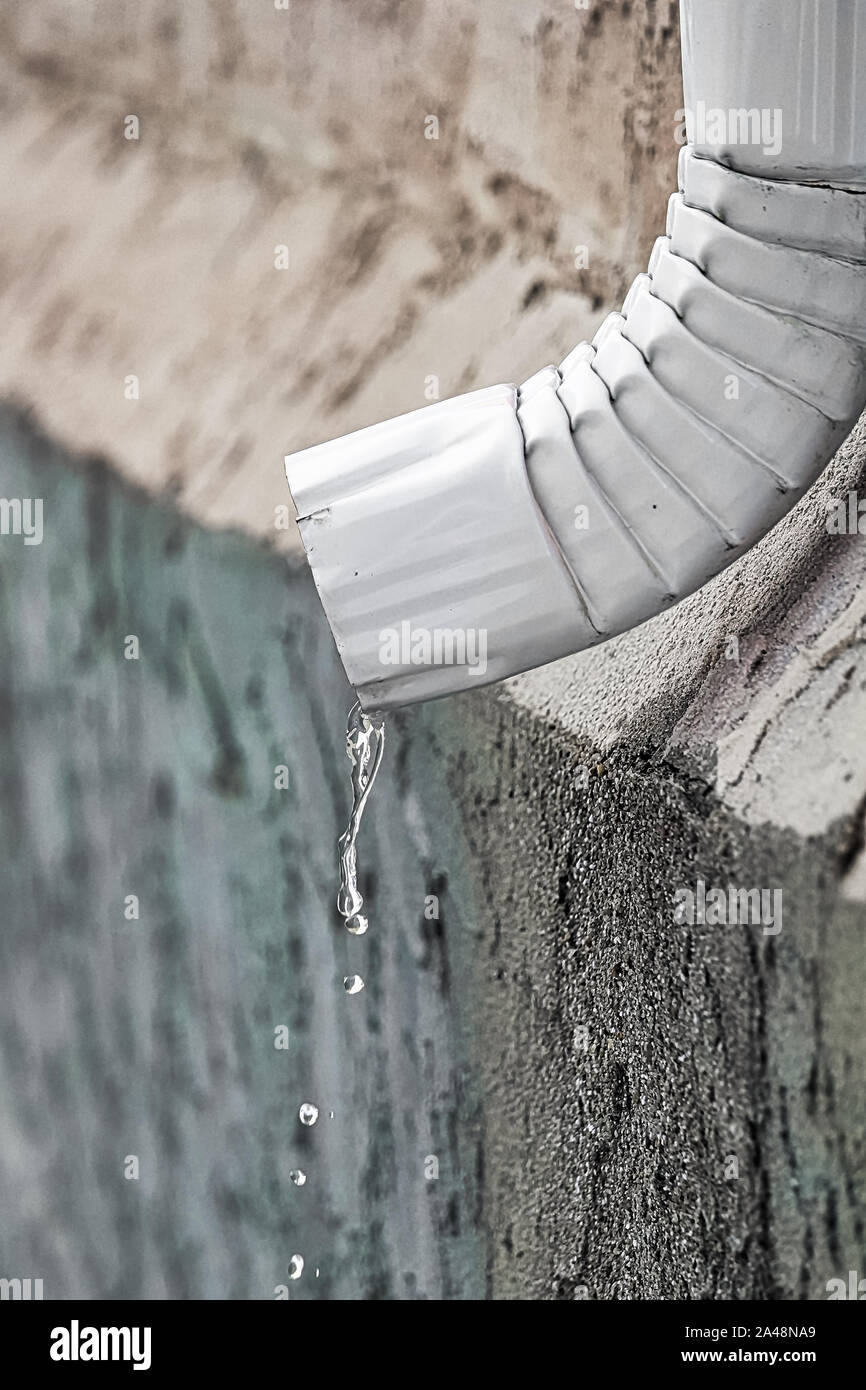 Water flowing out the end of an eavestrough Stock Photo - Alamy