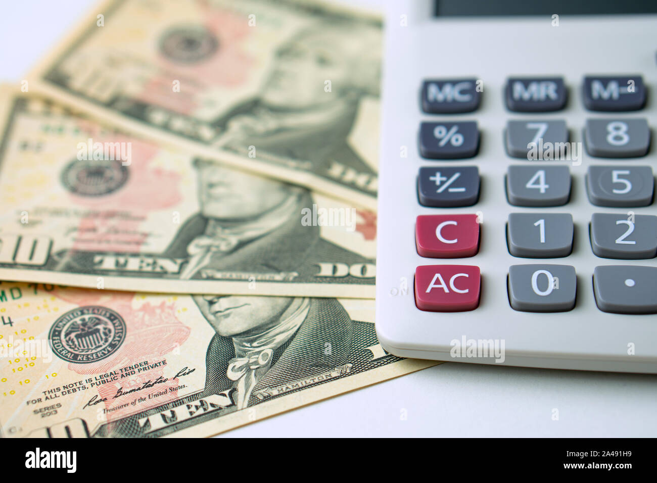 Calculator on ten dollars banknotes on a white background. Concept of ...