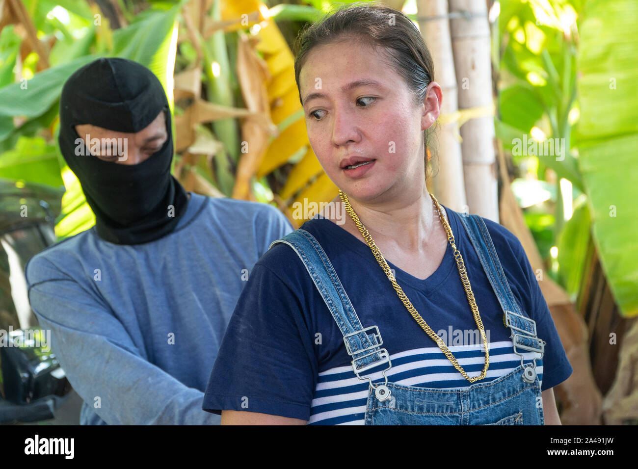 Man with masked robber and threatening with gun to scared woman in car ...