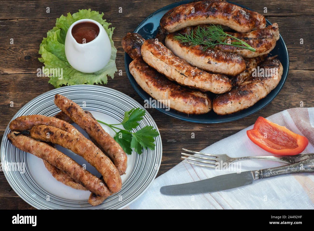 A grilled sausages on a plate on a kitchen table background Stock Photo ...