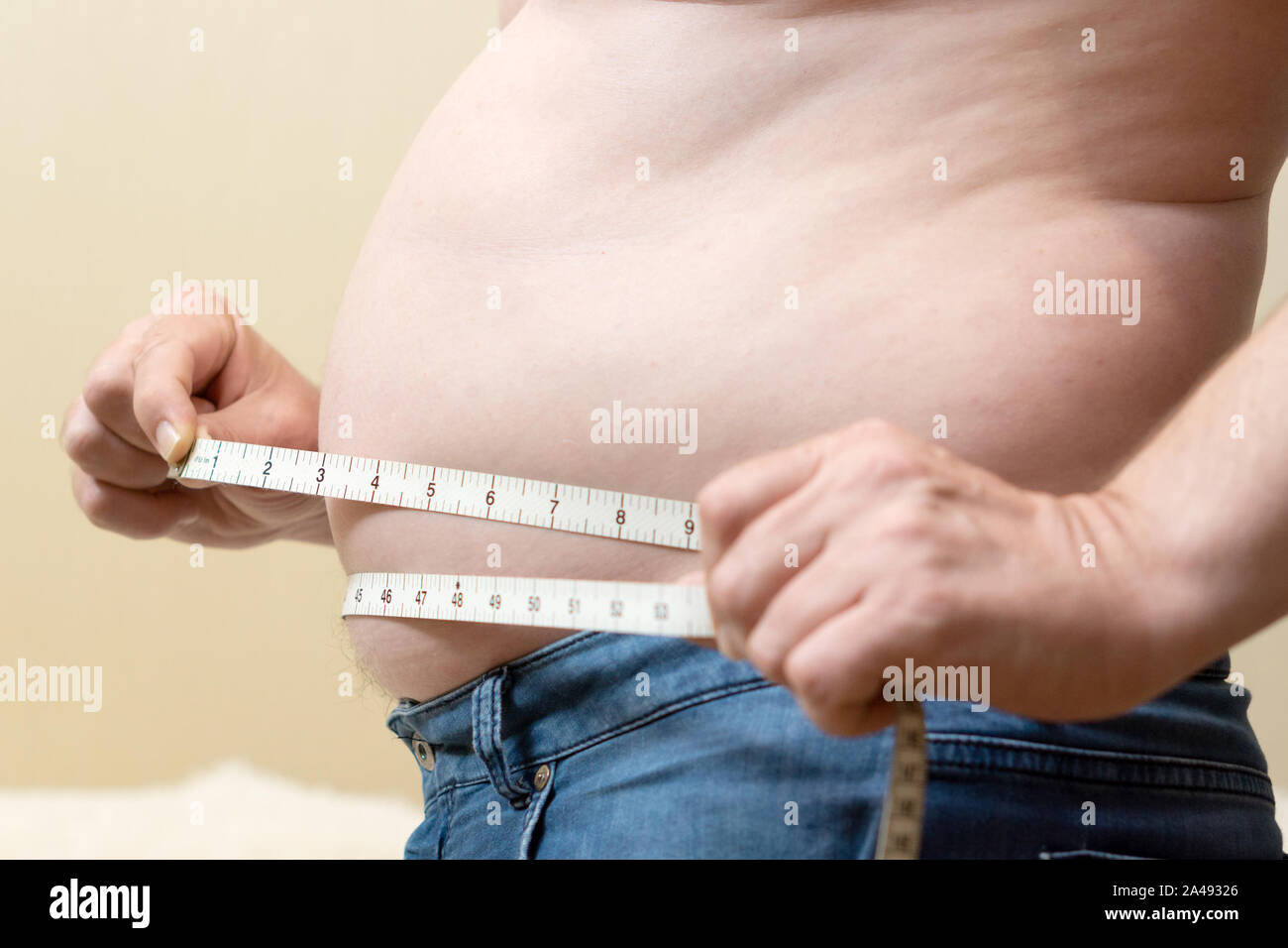Fat man in jeans measures the waist Stock Photo - Alamy