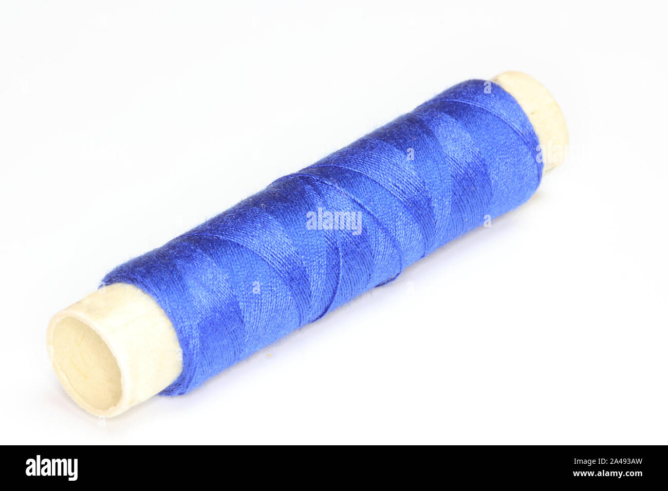 a spool of thread with a needle Stock Photo - Alamy