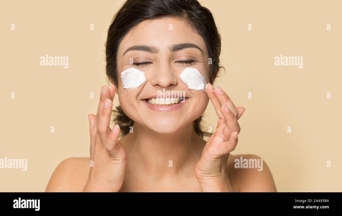 Smiling indian girl apply moisturizing face cream Stock Photo - Alamy