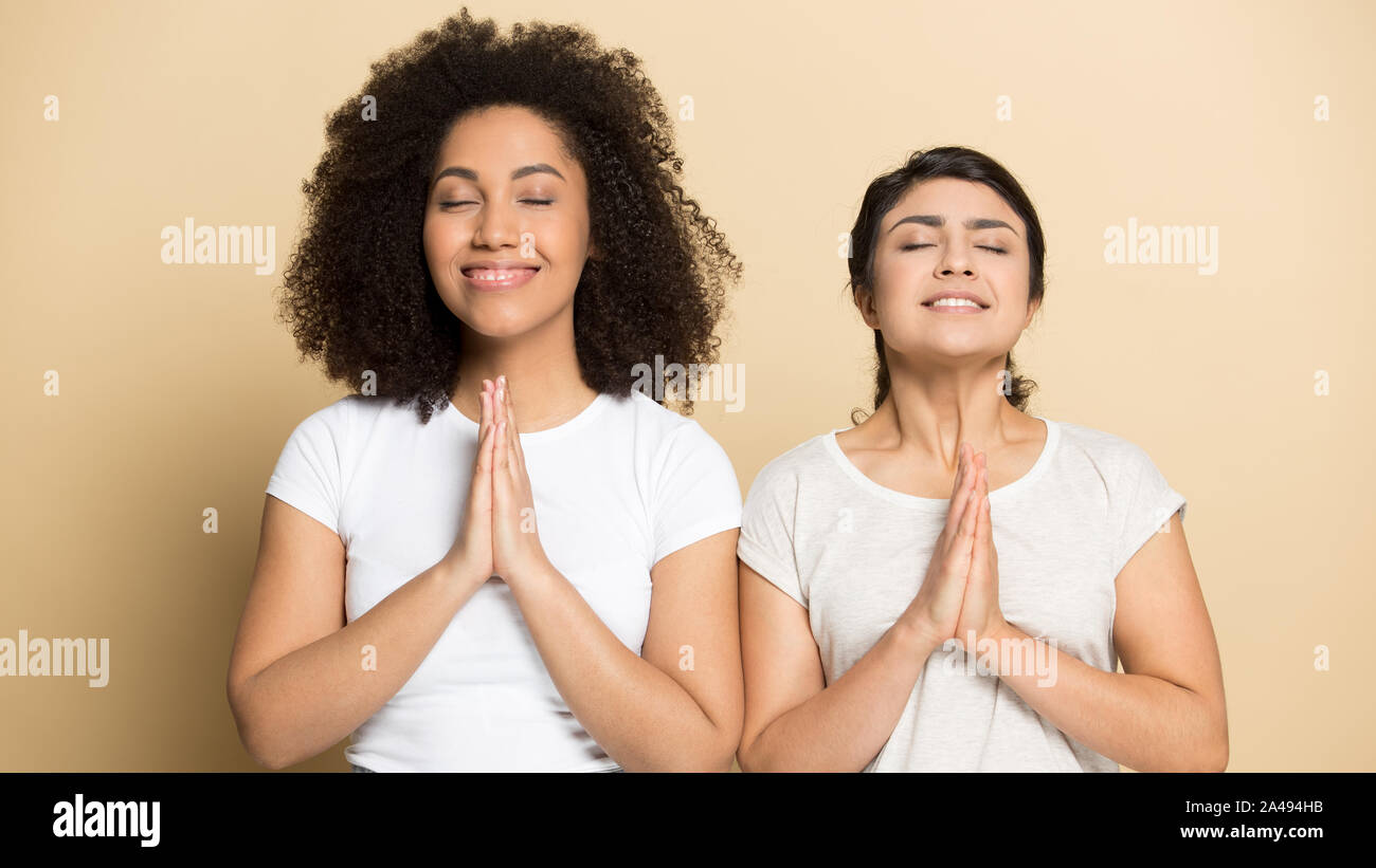 Happy multiethnic girls with prayer hands hope for luck Stock Photo - Alamy