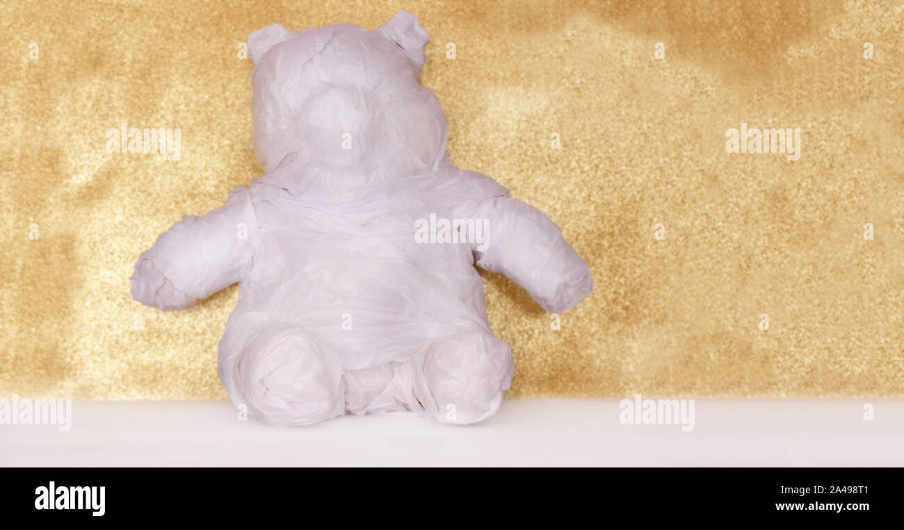 teddy bear wrapped in white paper for a gift on golden background Stock ...